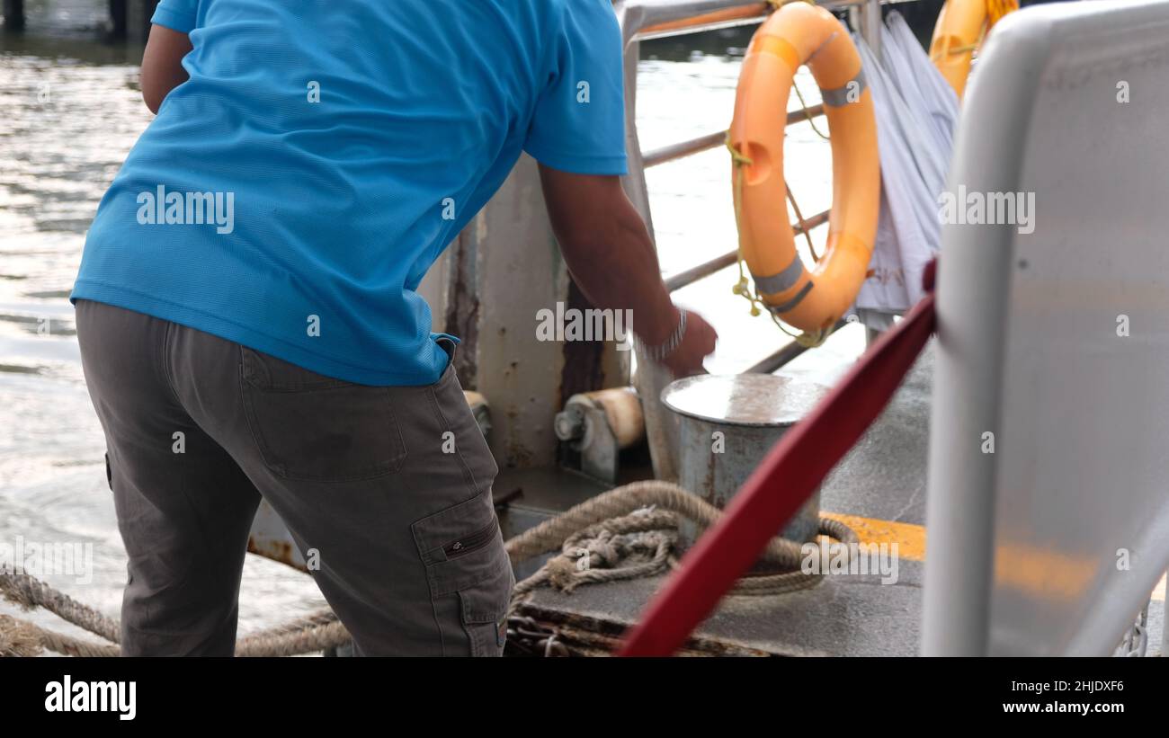 Orange Flag Express Boat Worker lassoing, tethering, tying and docking ...