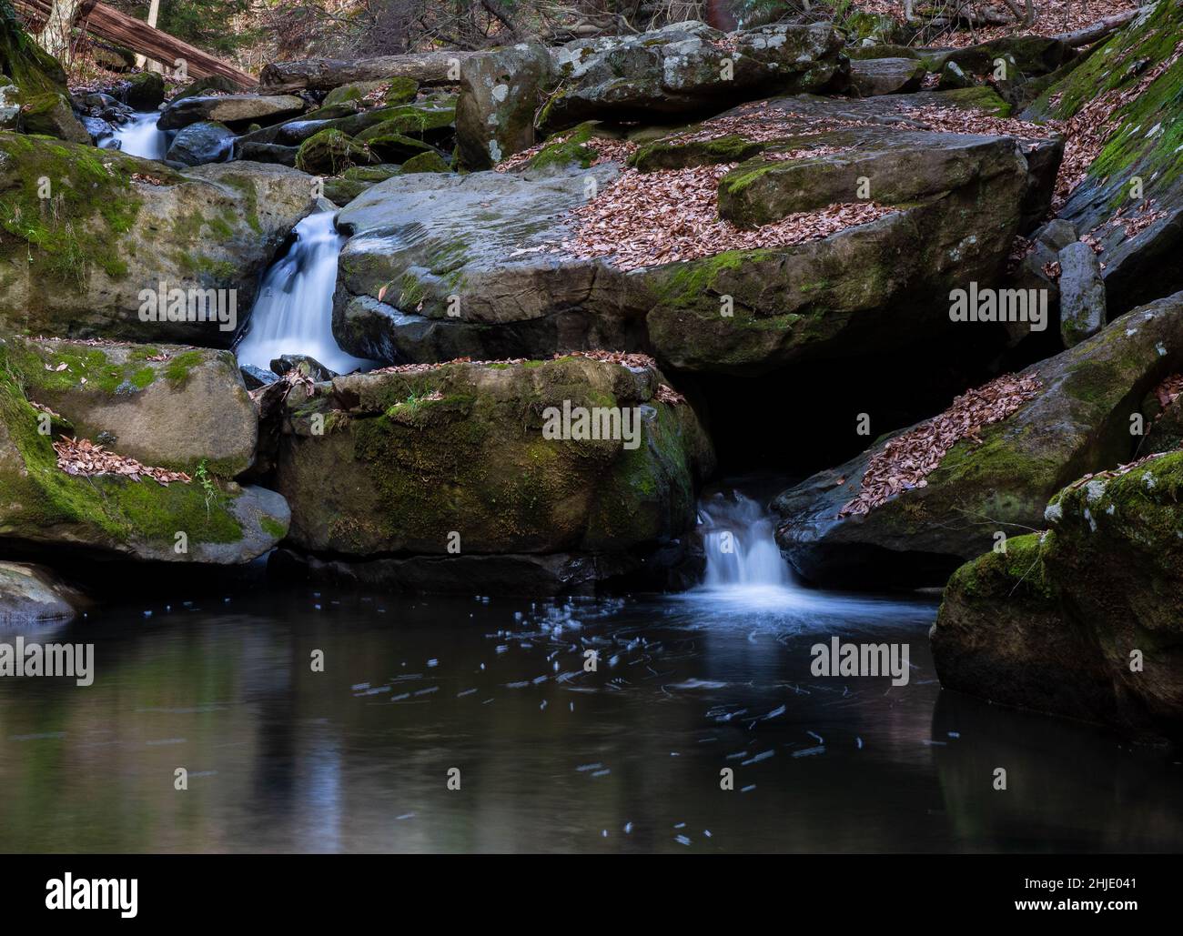 Beautiful view of a waterfall and rocks covered with fallen autumn ...