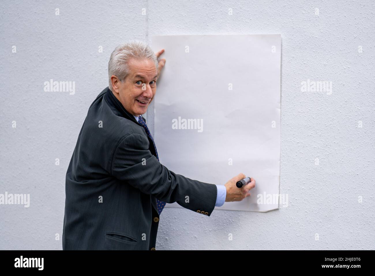 Photo of a senior businessman getting ready to write a message on a ...