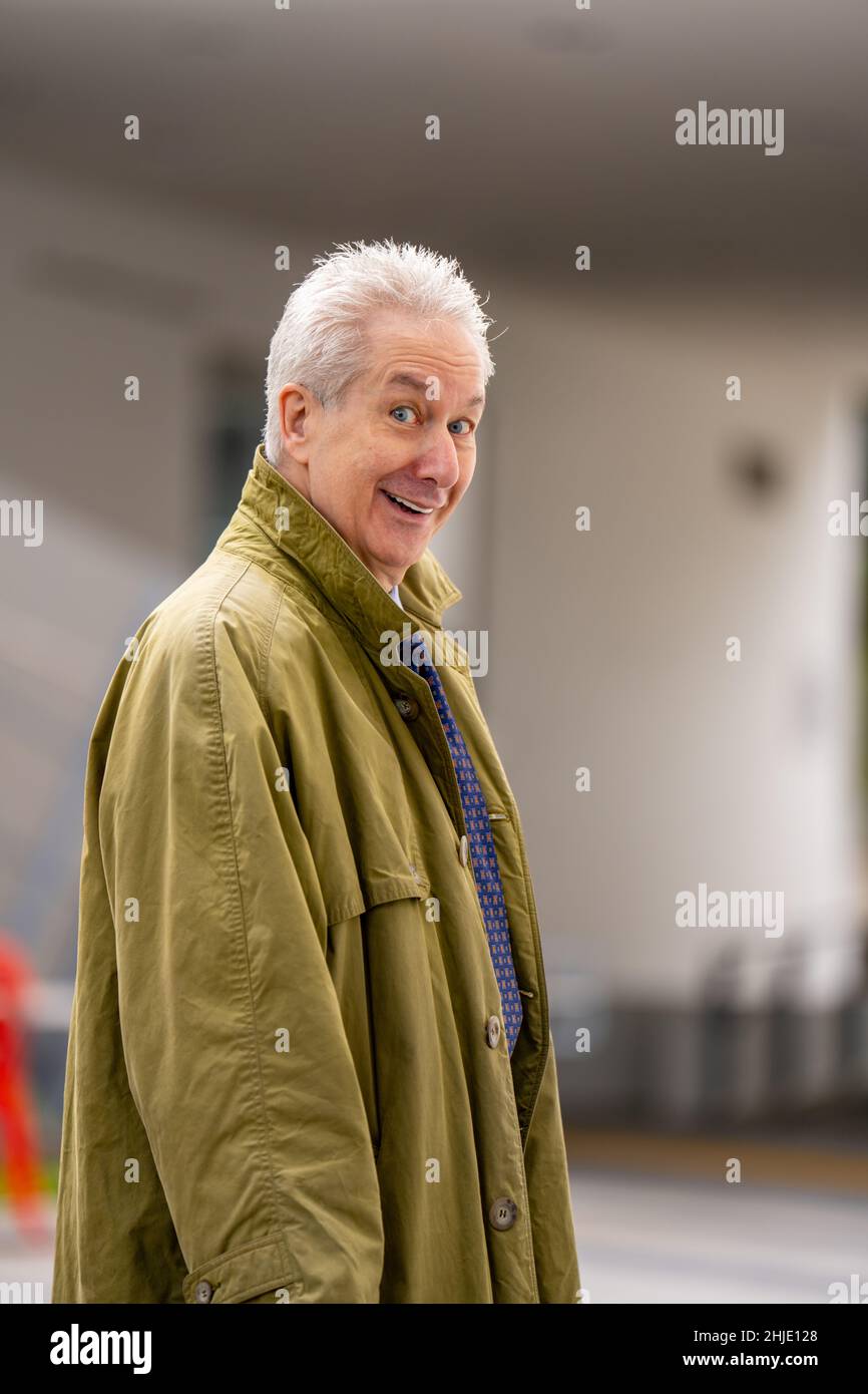 Old man posing in a green oversize trenchcoat Stock Photo - Alamy