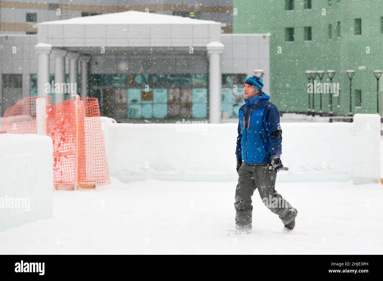 The master with a chisel in his hand walks through the ice town in the ...