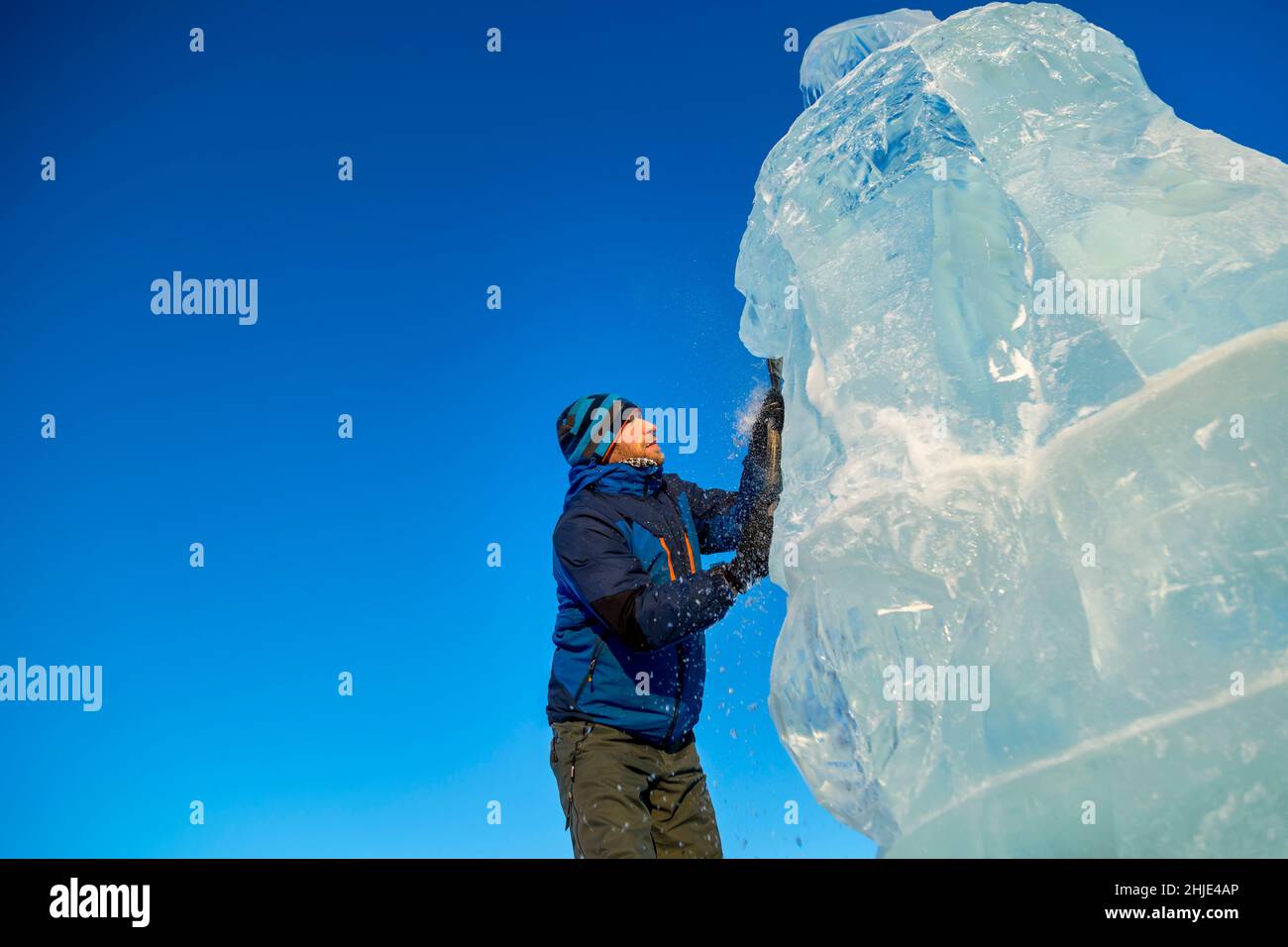 The sculptor cuts an ice figure out of a block of ice for Christmas ...