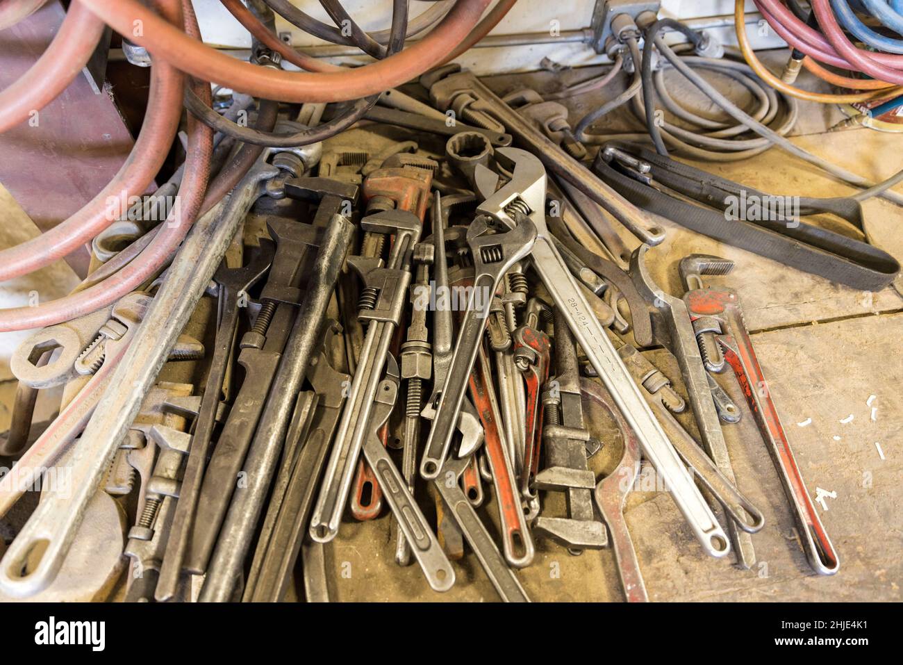Wrenches of many varieties, well used tools on a bench with air hoses ...
