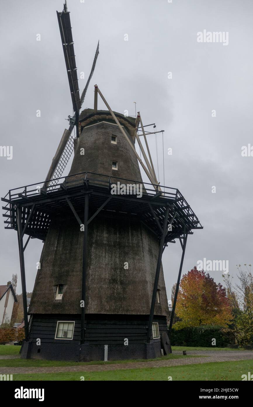 A vertical shot of an old, broken windmill on cloudy sky background ...