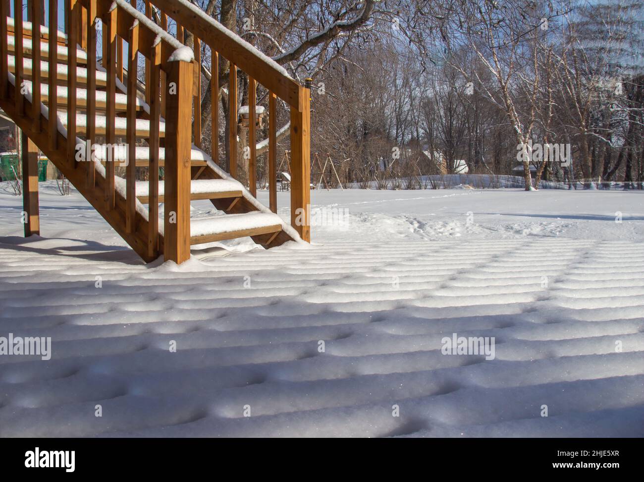 Outdoor view of fresh snow texture designs on a wooden deck and ...