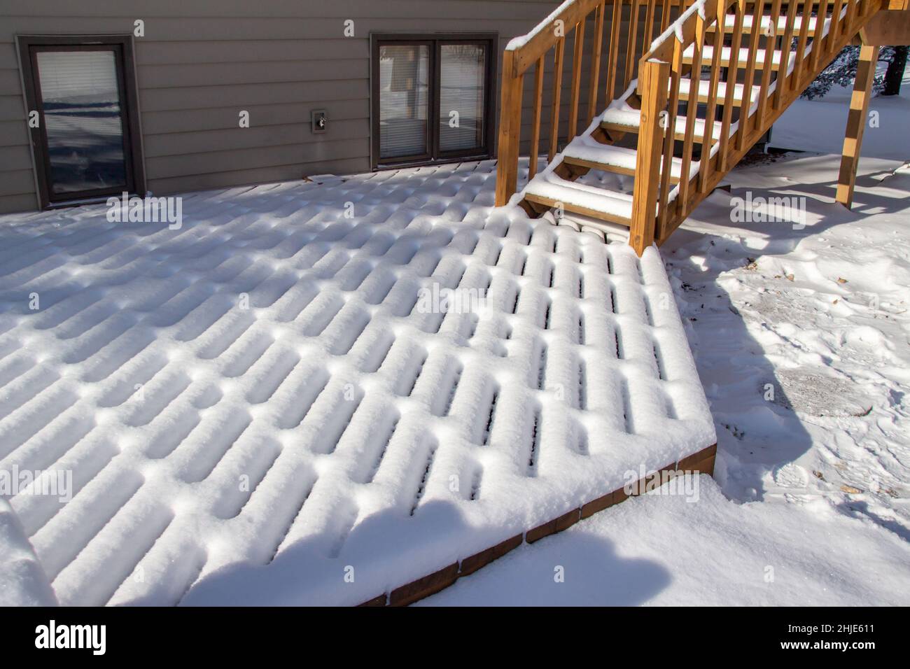 Outdoor view of fresh snow texture designs on a wooden deck and ...