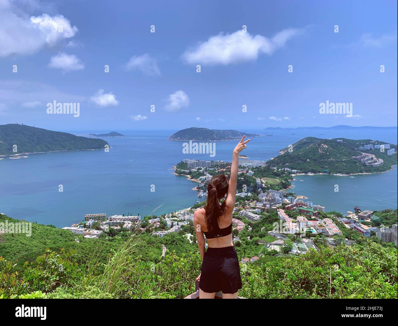 Cool athlete female showing the victory sign standing on the top of the ...