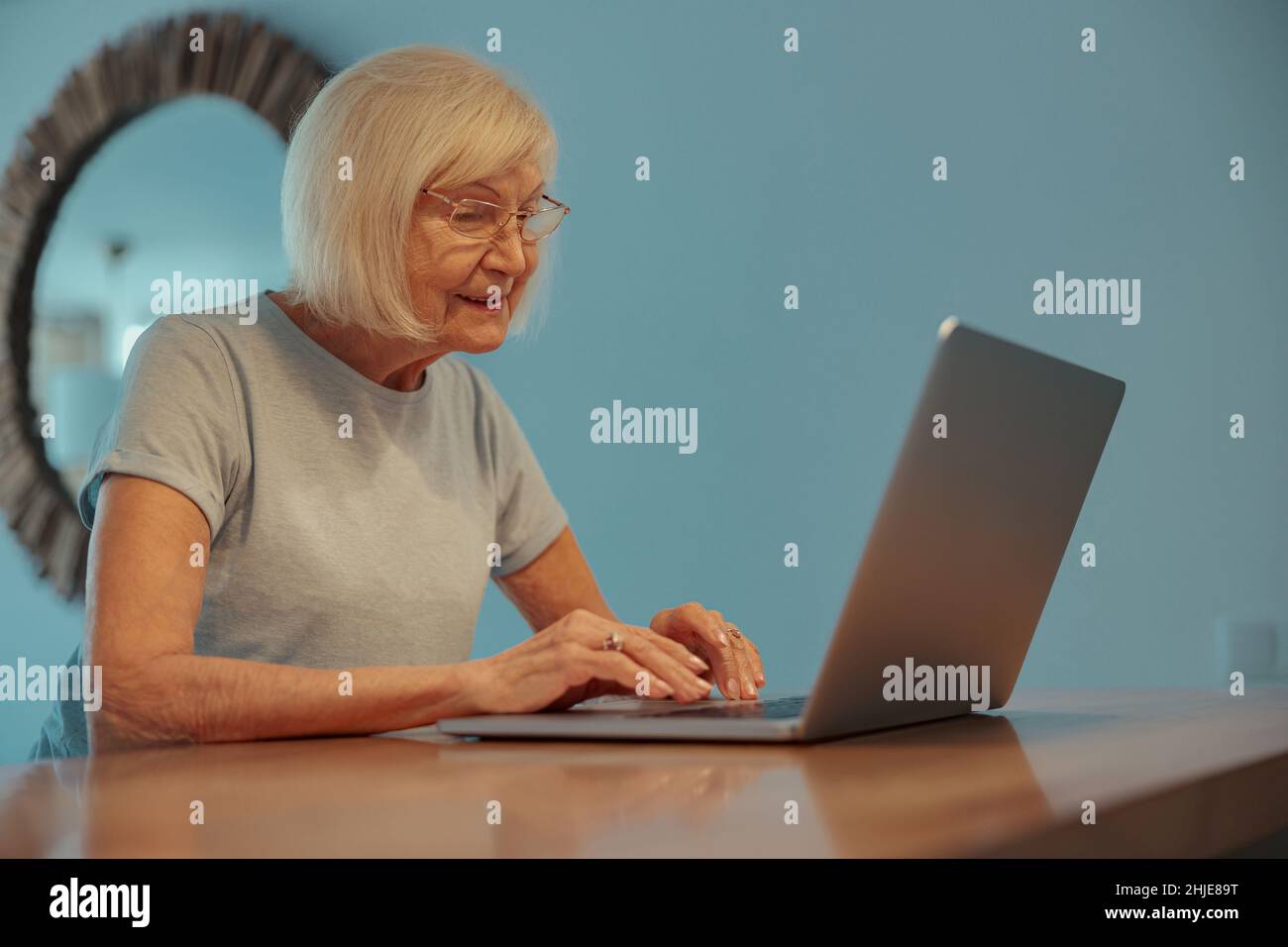 Modern aged woman using laptop computer at home Stock Photo - Alamy