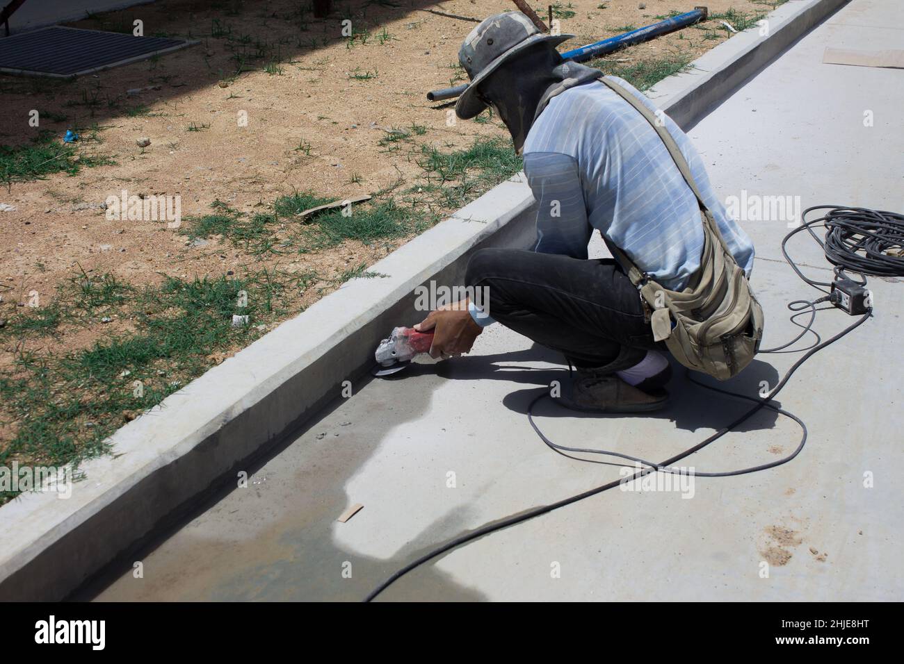 Builder worker with cut-off machine power tool breaking asphalt at road ...