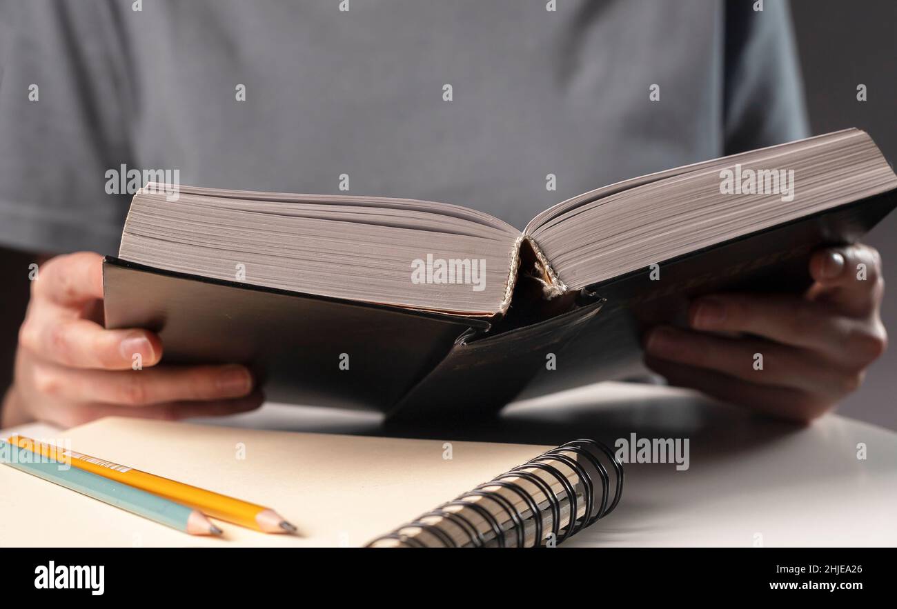 Female student hands close up, pointing on text in book or textbook ...