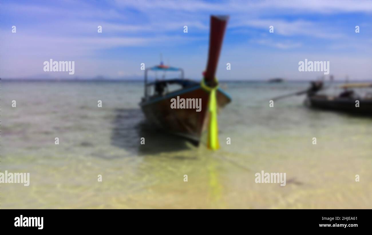 Small boat washed up on shore, bright blue sky in background. blur ...