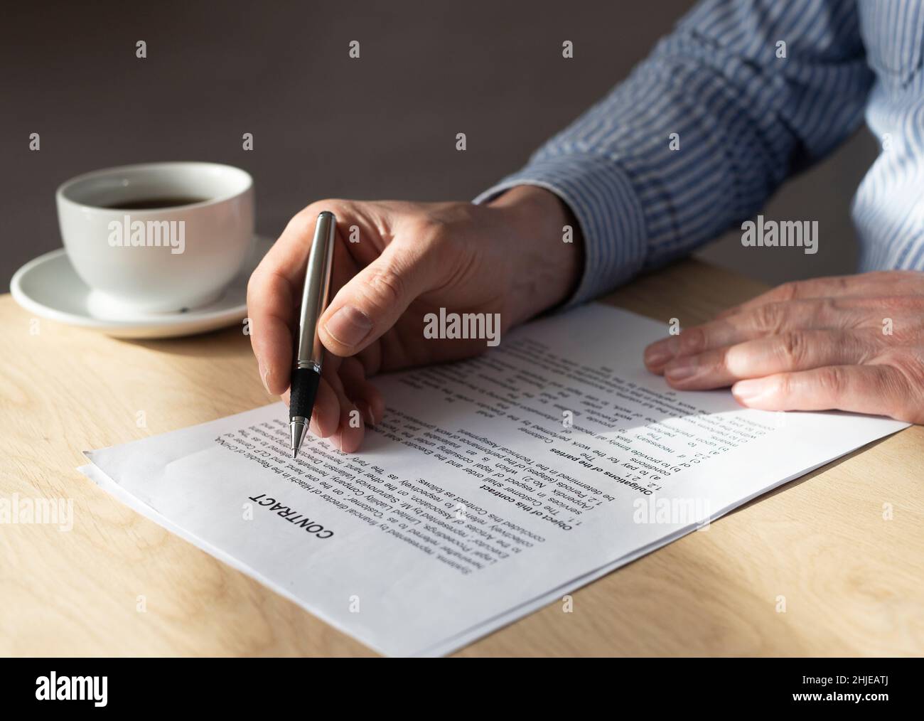Man reading contract to sign it at office desk Stock Photo - Alamy