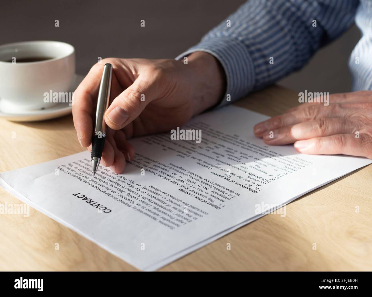 Man reading contract to sign it at office desk Stock Photo - Alamy