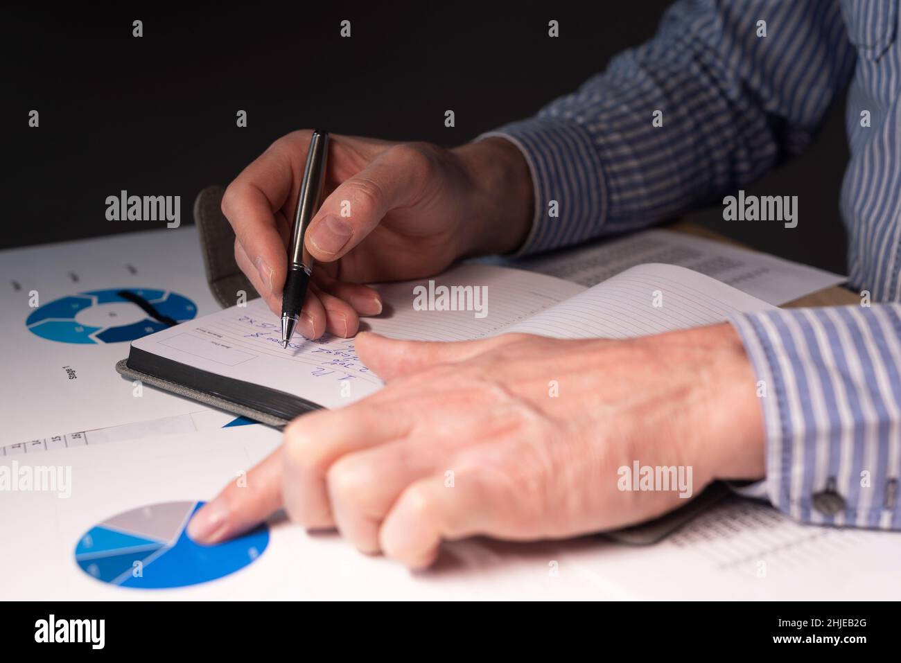 Businessman at desk with financial documents, preparing finance report ...