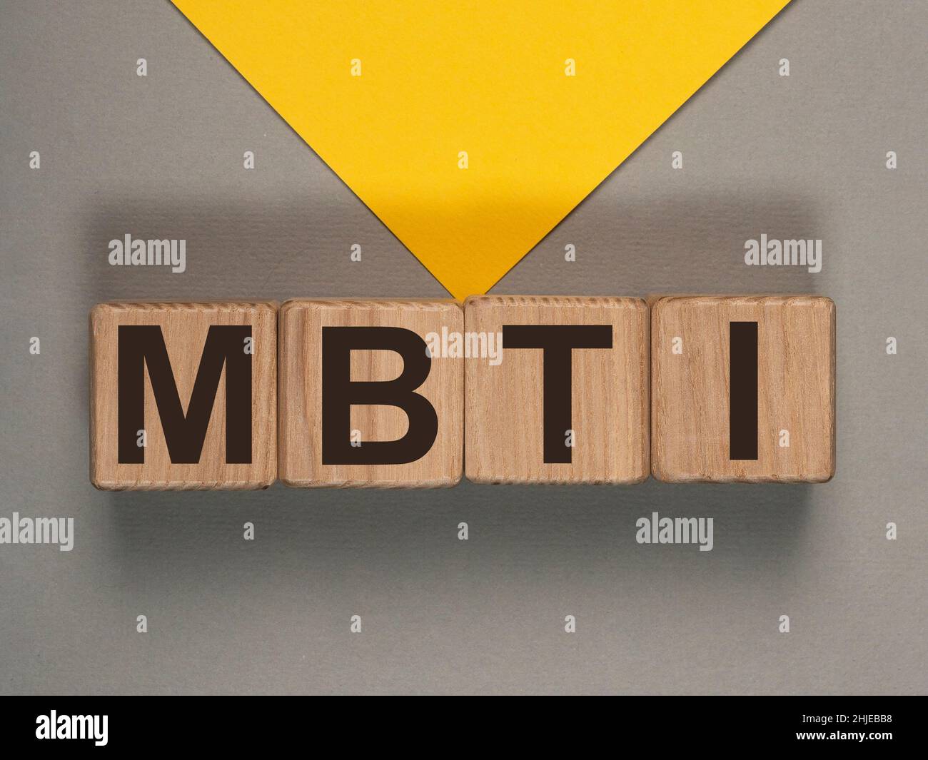 MBTI acronym on wood cubes on gray and yellow background. Psychological ...