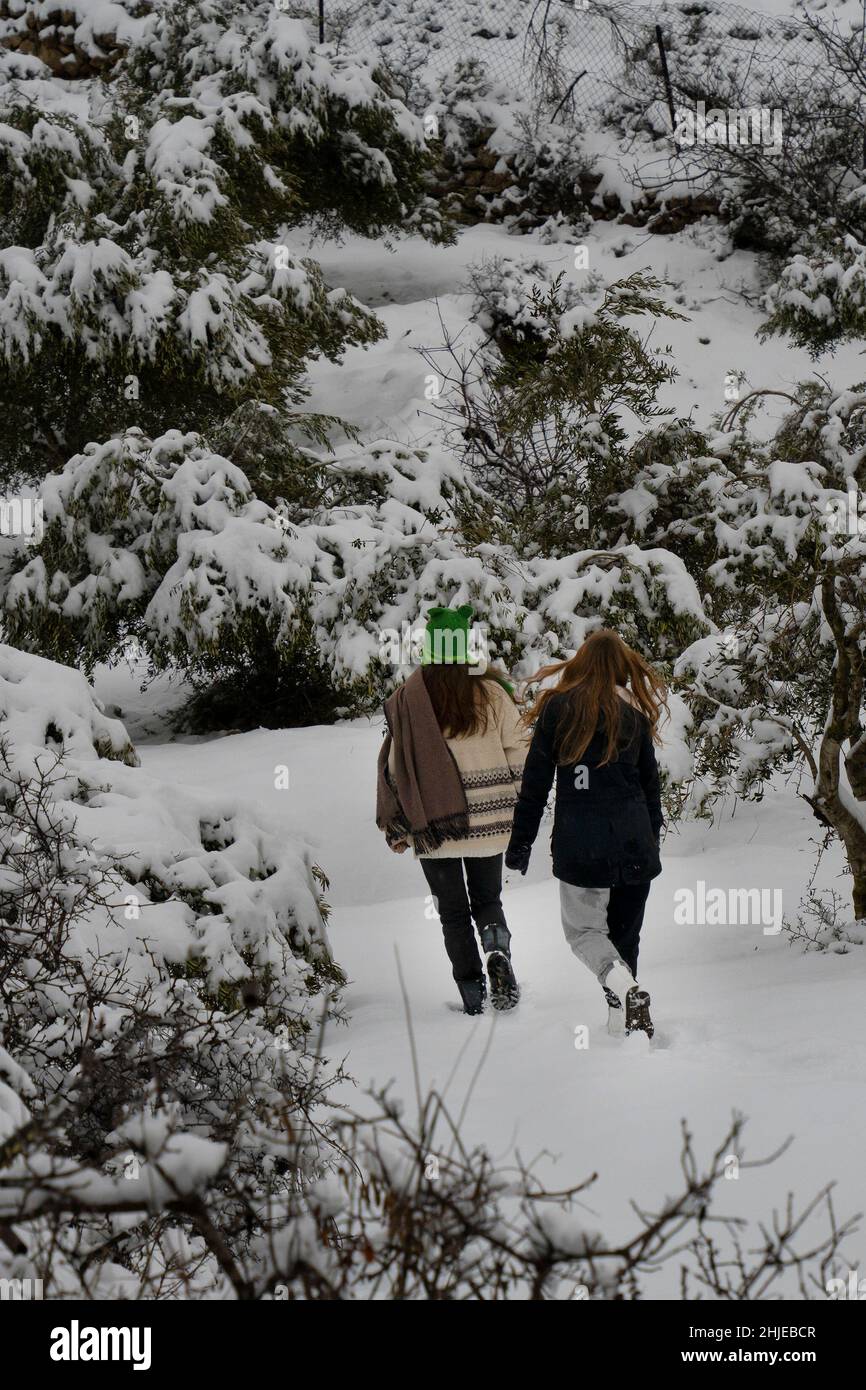 Two young women taking a walk in the snow in the Judea Mountains near ...