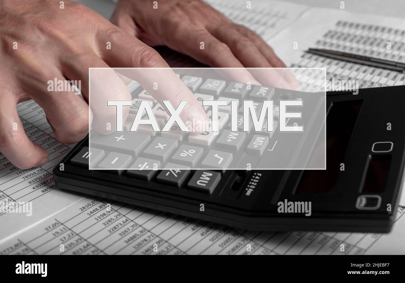 Tax time text on image of hand calculating on calculator. Taxation ...