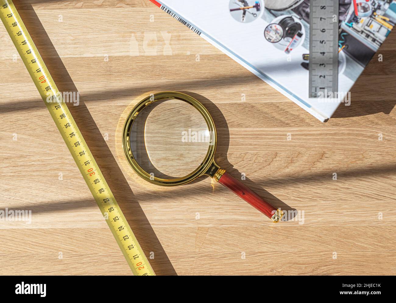 Technical flatlay with magnifying glass, ruler, tape measure and book ...