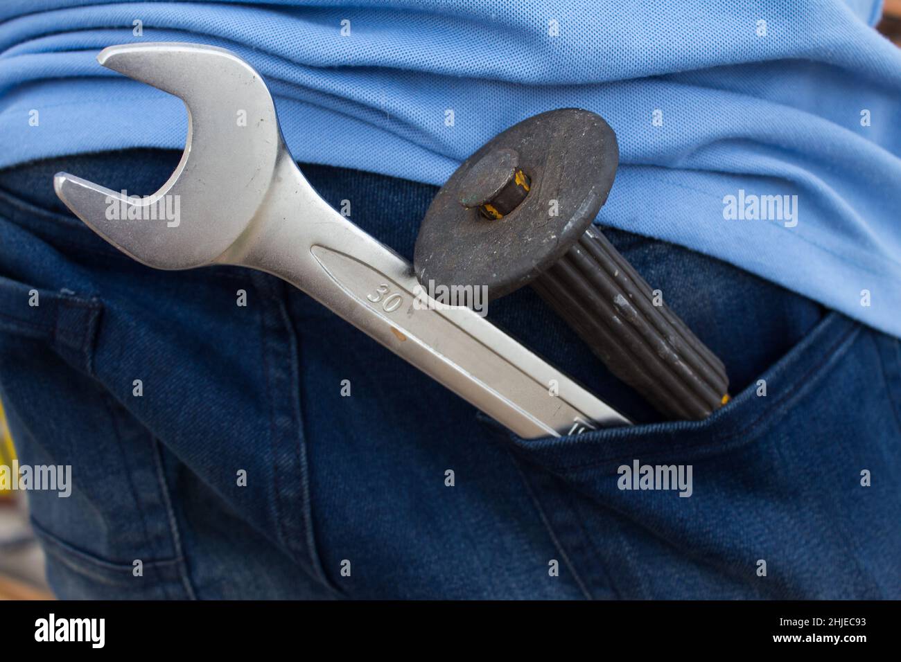 Wrench in the back pocket of jeans. Large and small wrenches as a ...