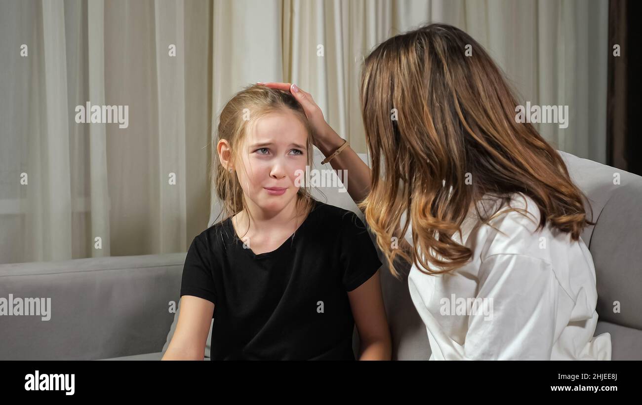 Teen girl complains crying while mother calms daughter Stock Photo - Alamy