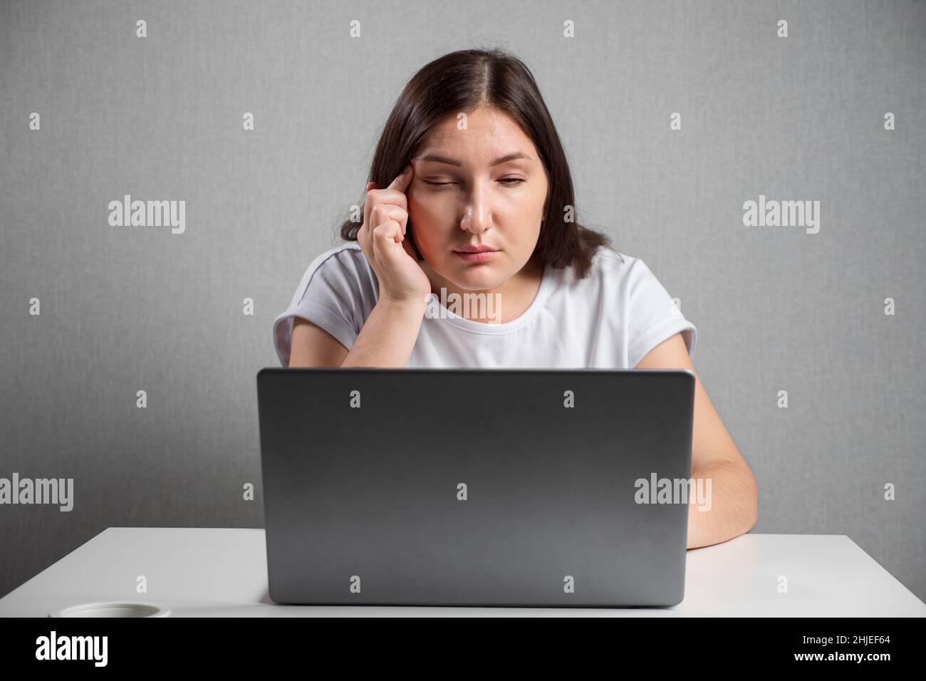 Woman with poor eyesight looks at laptop screen squinting Stock Photo ...