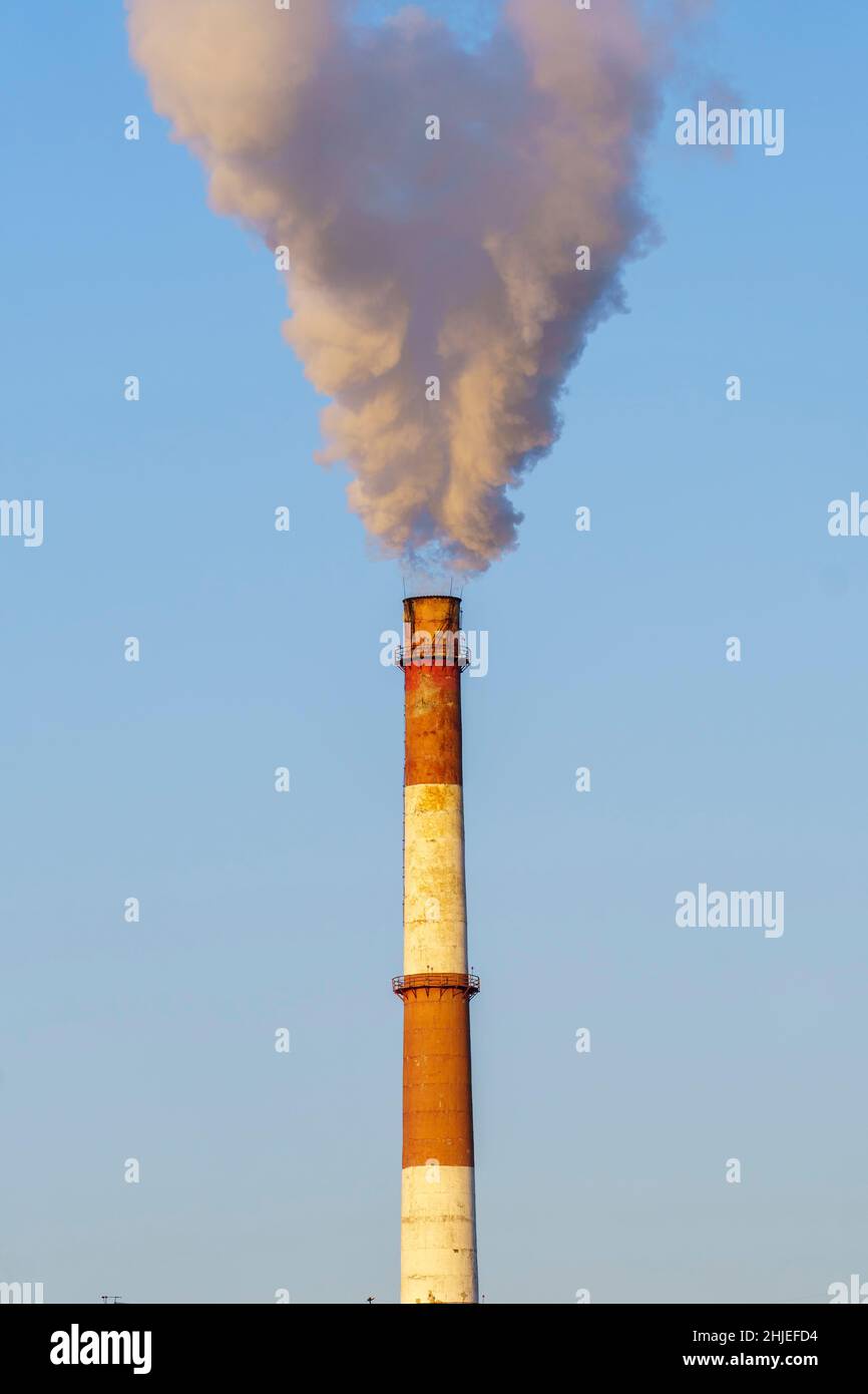 White thick smoke from the boiler room chimney. Smoke against the blue ...