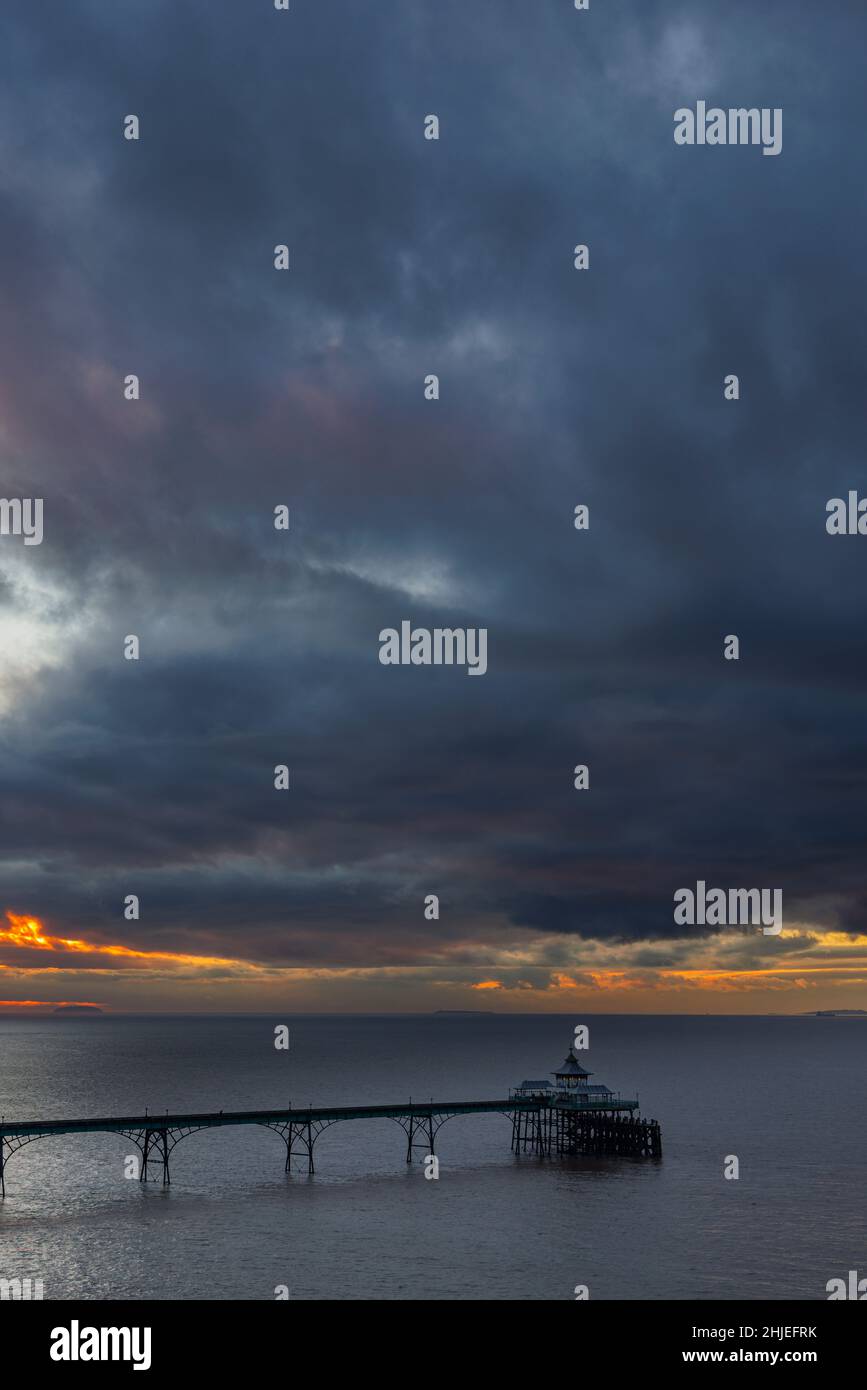 With dark clouds overhead with a slight pinkish hue on the underside of ...