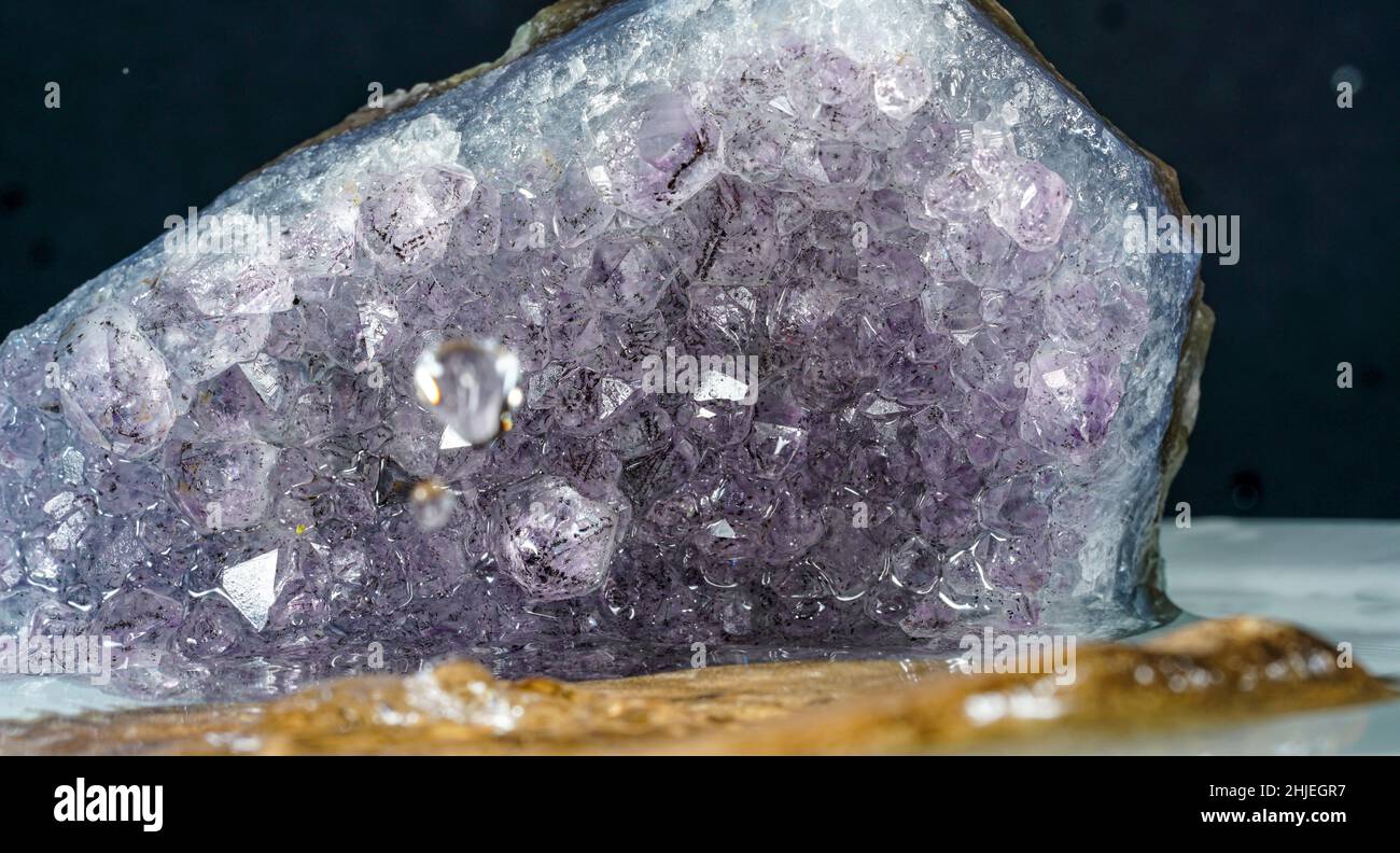 Quartz with mineral inclusions in the studio in front of black ...