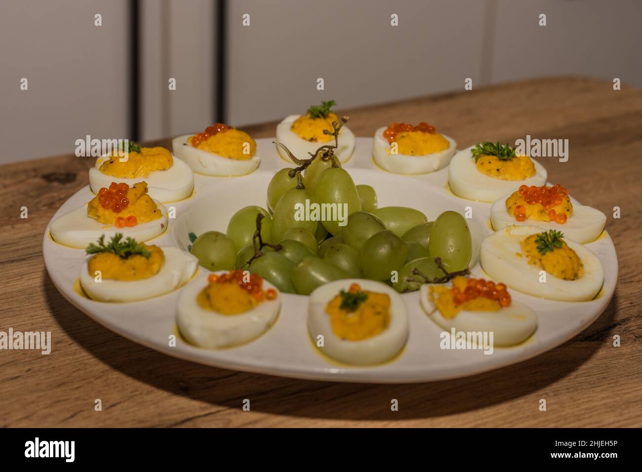 plate with fresh tasty eggs and mayonnaise cream such as grapes in the ...