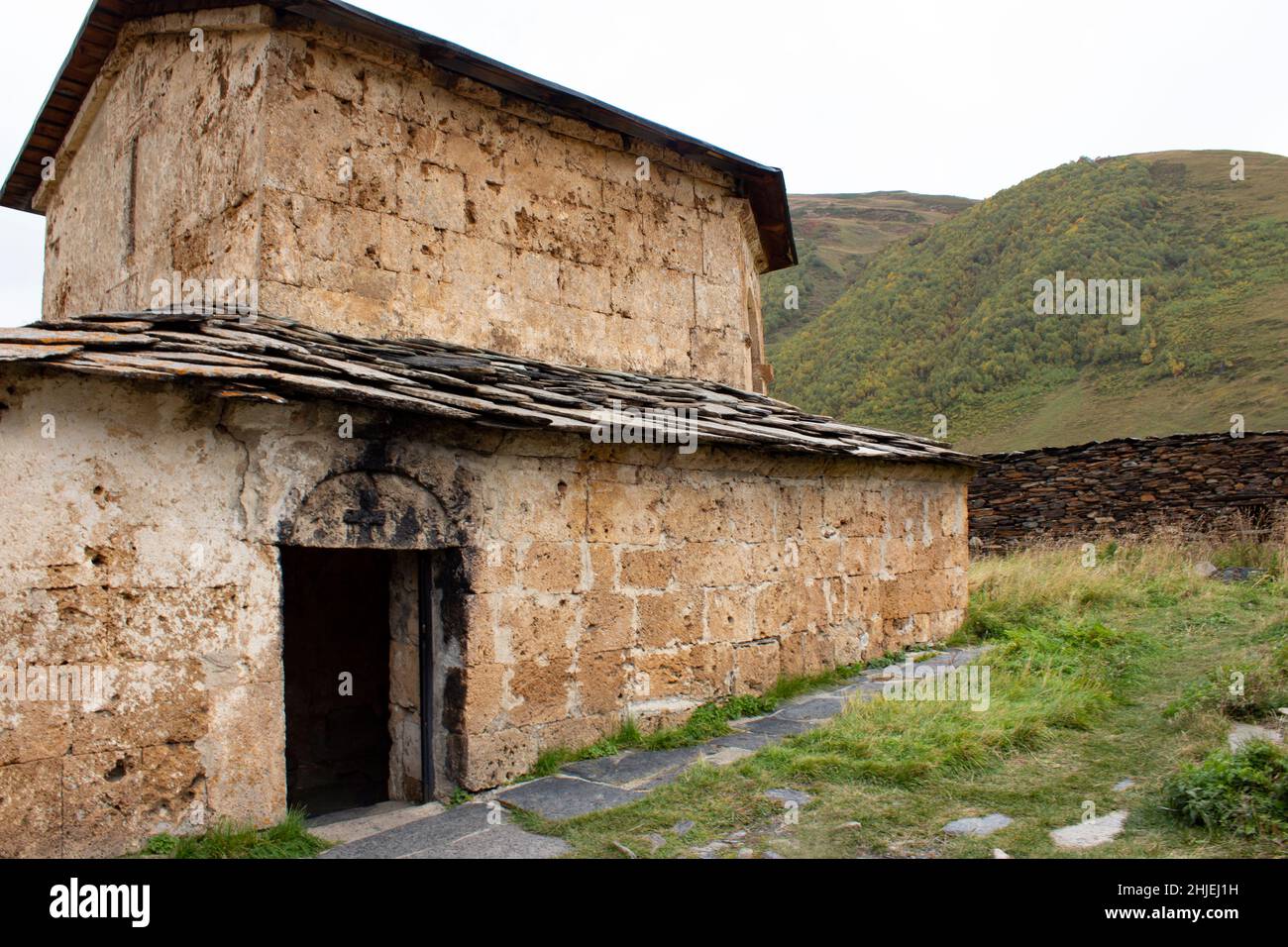 Ancient stone monastery high in the Caucasus mountains on a summer day ...