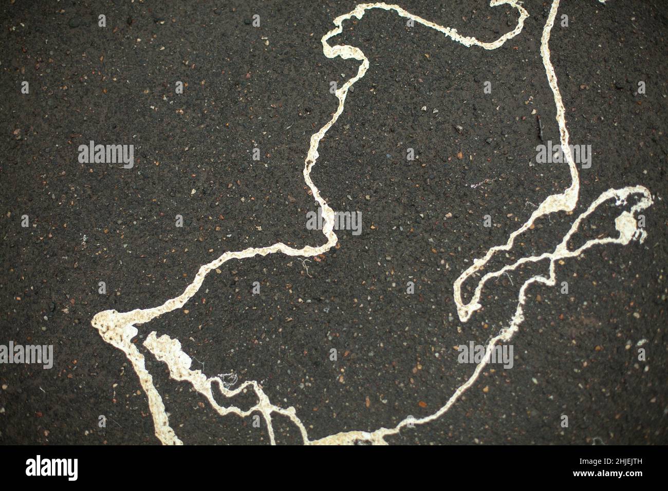 Paint on asphalt. Splashes of white paint on road. Soiled surface ...
