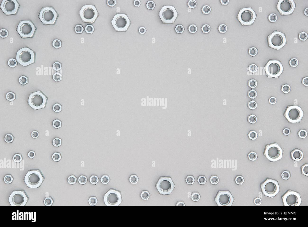 Frame made with metal hexagon nuts on gray background. Abstract border ...