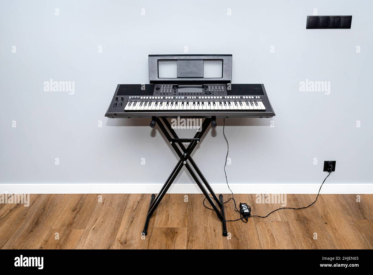 Electric keyboard for playing and mixing music standing on a stand by ...