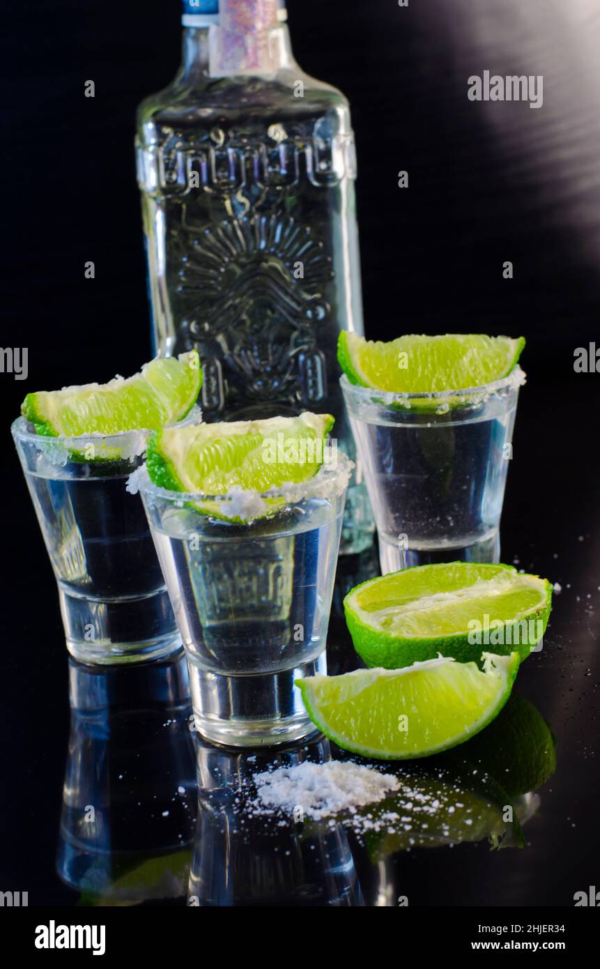 Silver tequila with lime and salt on a black table Stock Photo - Alamy