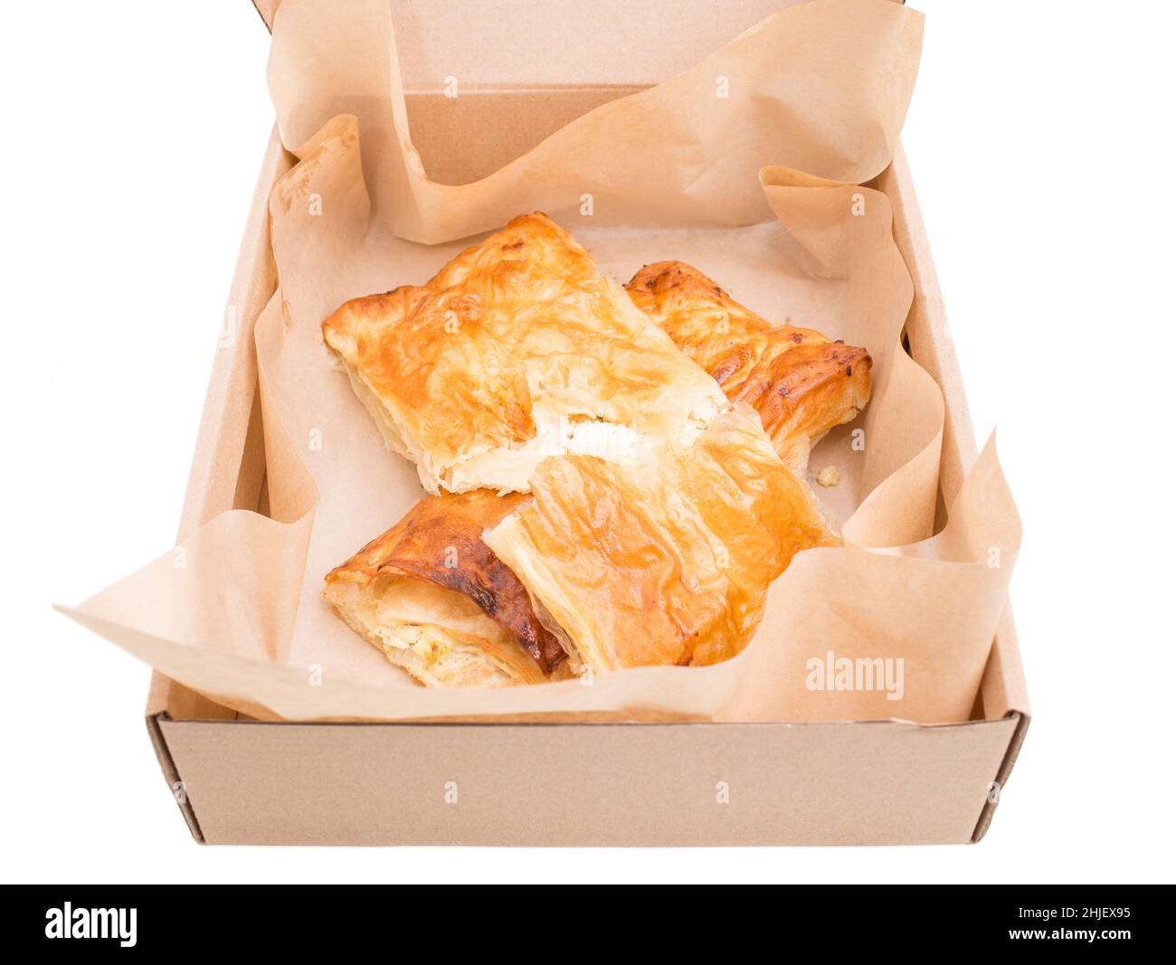 Heat puff cakes filled with a soft cheese in cardboard box. Isolated on ...