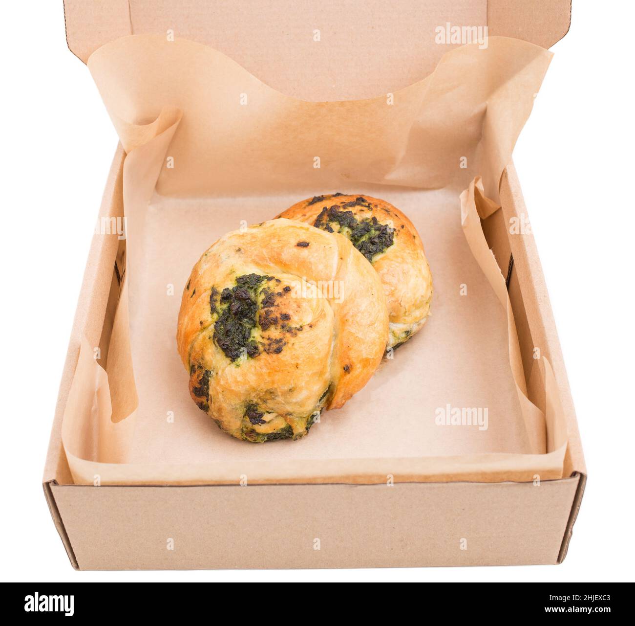 Heat spinach puff cakes in cardboard box. Isolated on a white ...