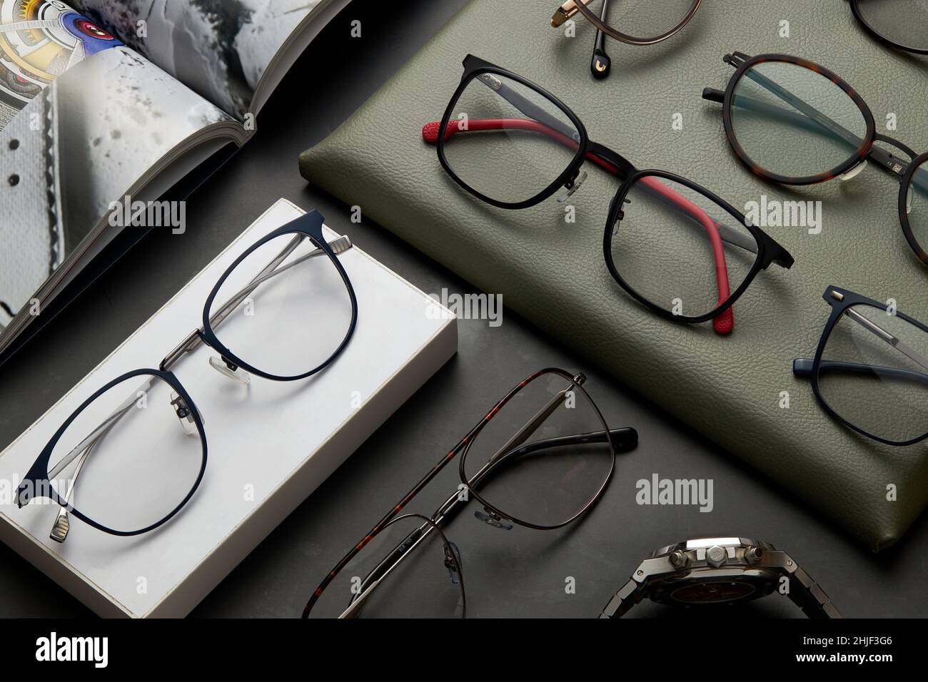 Photo of eyeglasses of different frames colors and shapes and a watch ...