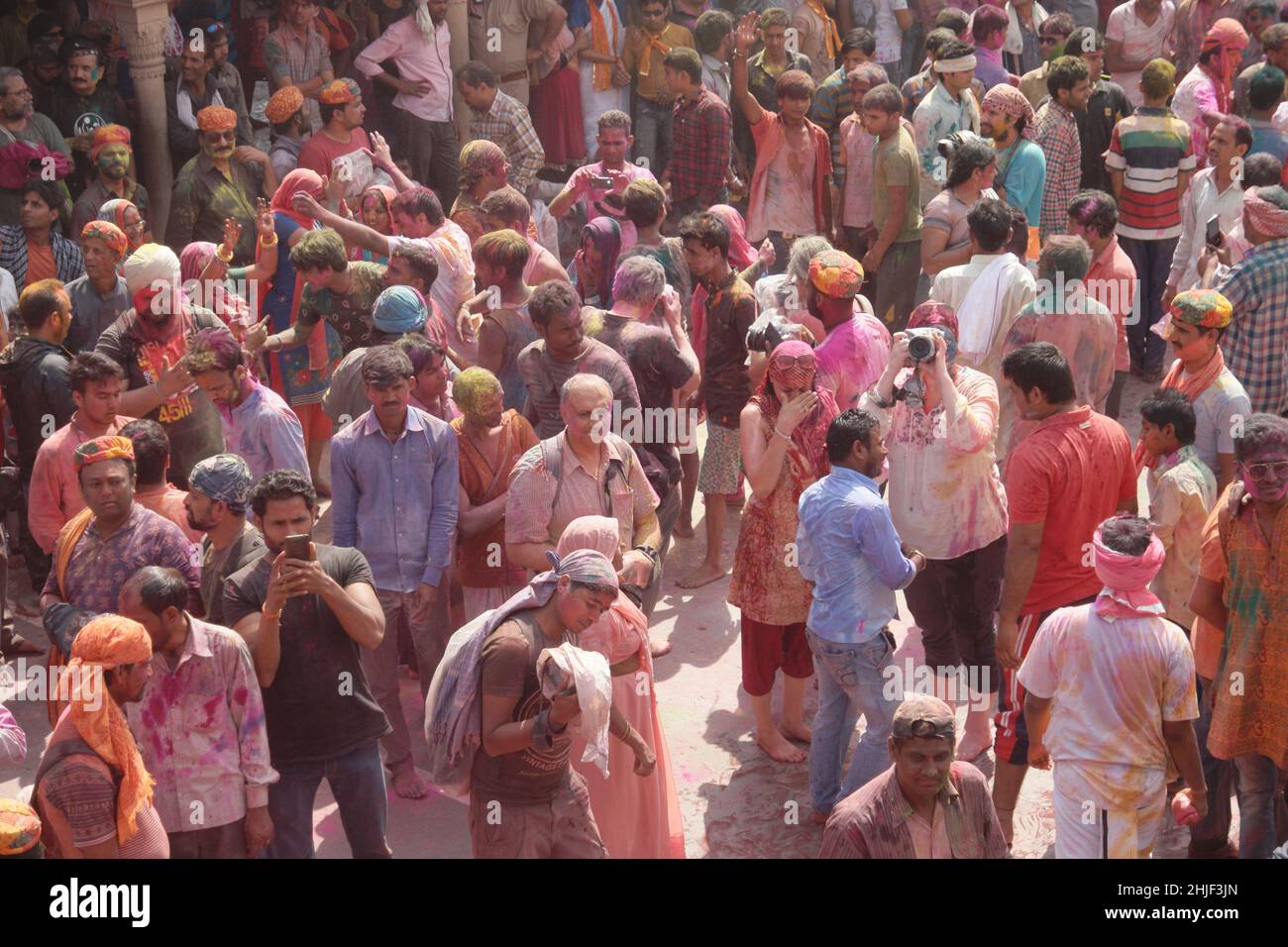 Visitors and local Indians all covered in colors celebrating the Holi ...
