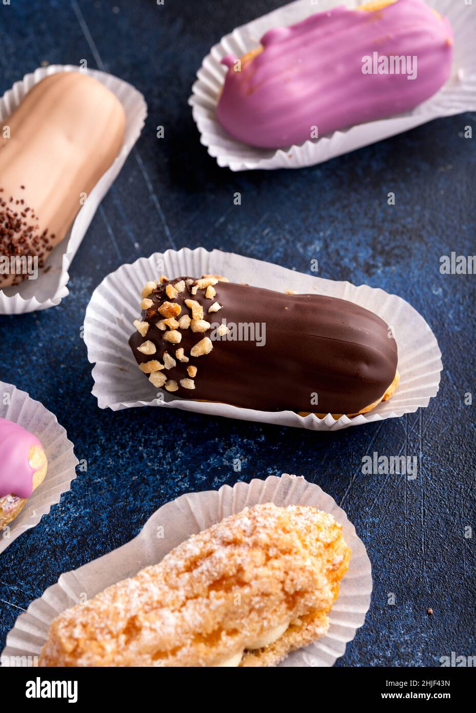 Beautiful delicious French eclairs with custard, covered with multi ...