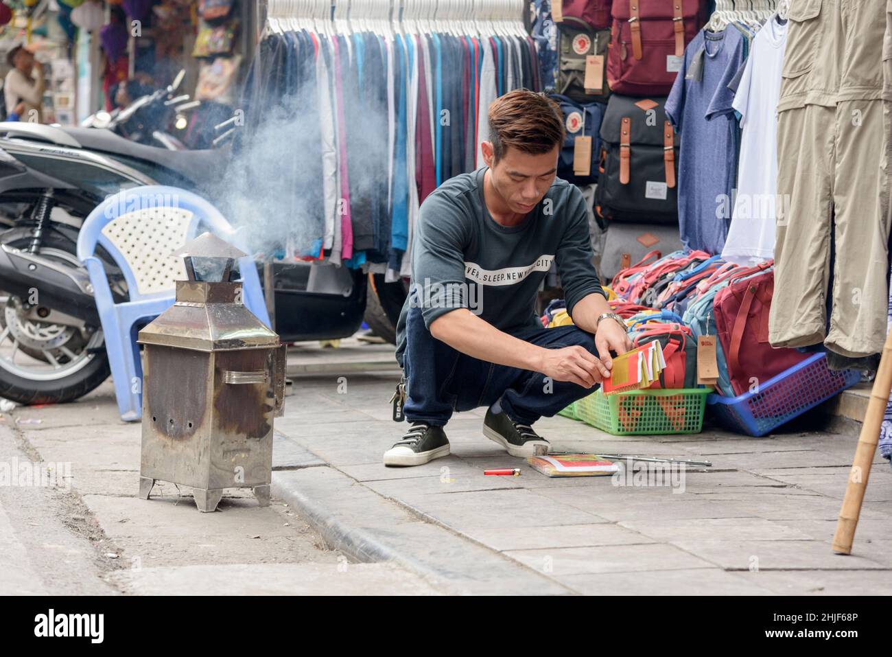 A Vietnamese man burns votive money (joss paper, fake money, spirit ...