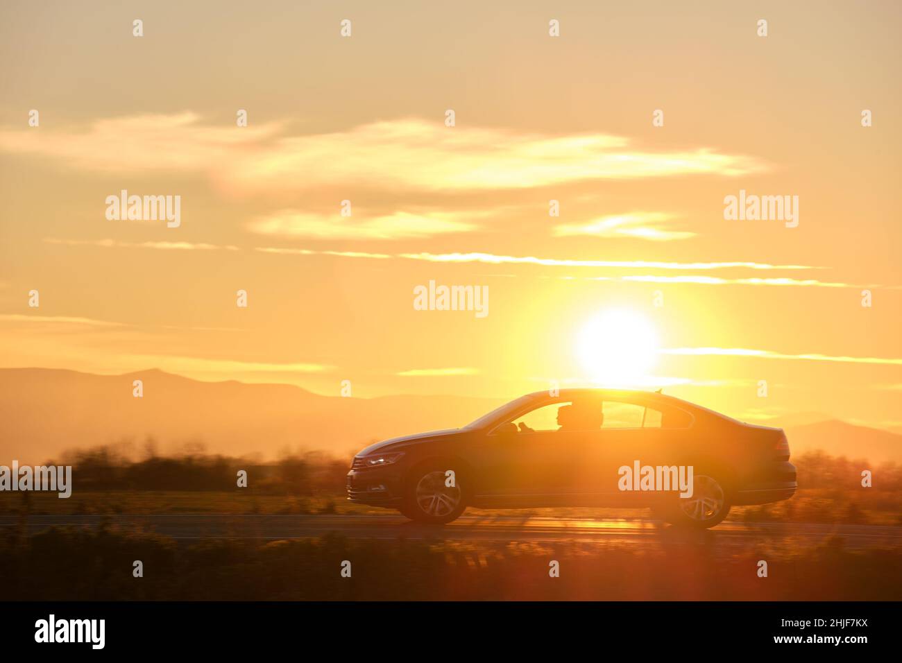 Car driving fast on intercity road at sunset. Highway traffic in ...