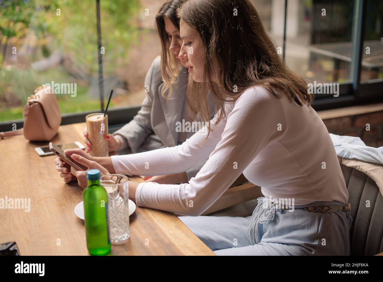 Amazing two sisters are talking while one of them is showing her sister ...
