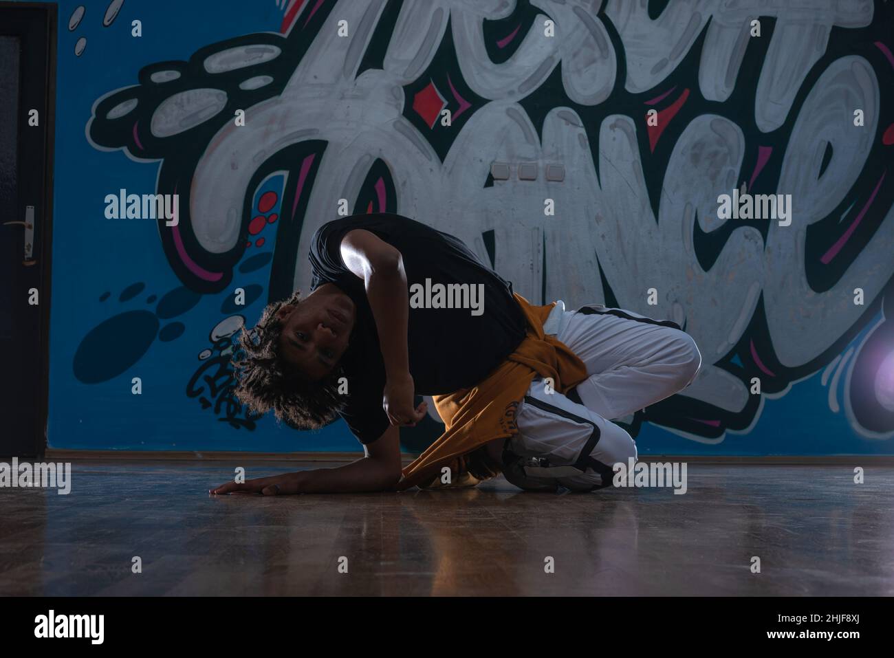 African American hip hop dancer (breakdancer) performing over graffiti ...