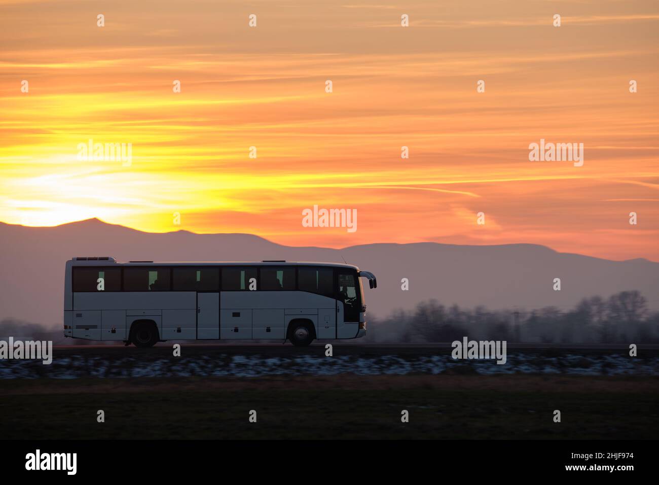 Intercity passenger bus driving on highway road in evening Stock Photo ...