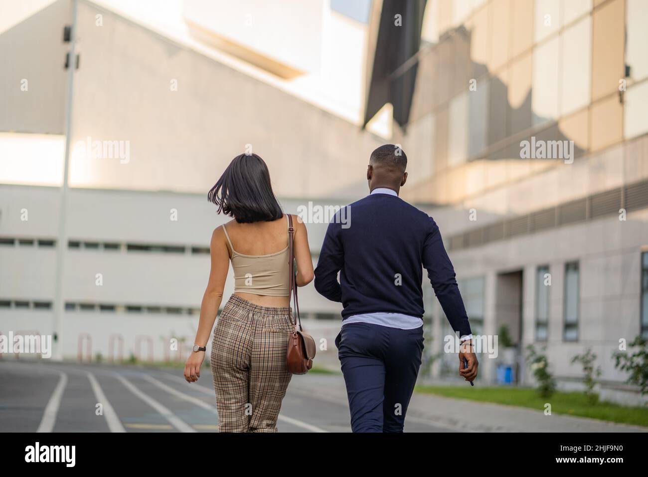 Two young and beautiful business partners are walking together towards ...