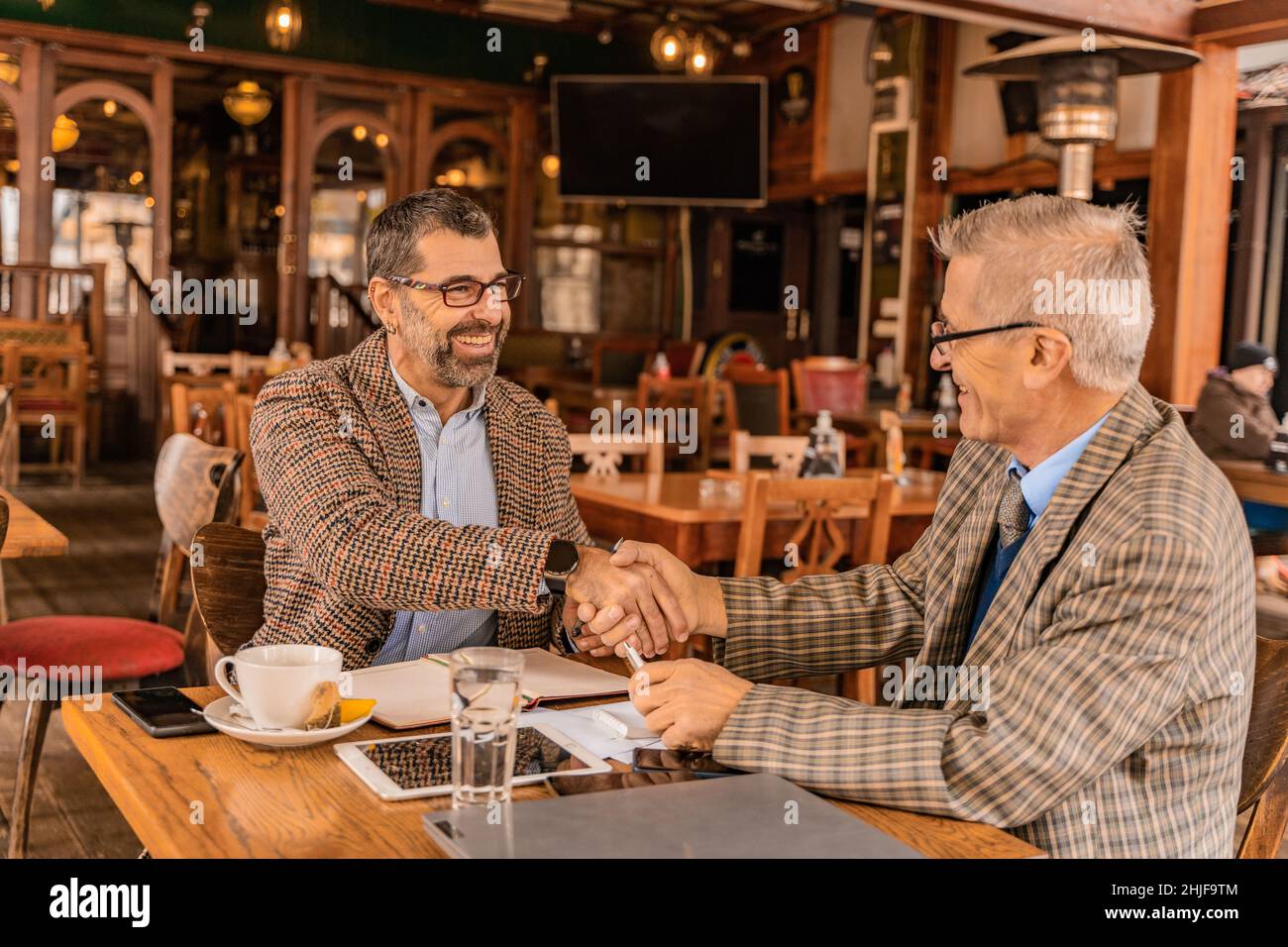 Two senior and handsome businessmen are making a deal Stock Photo - Alamy