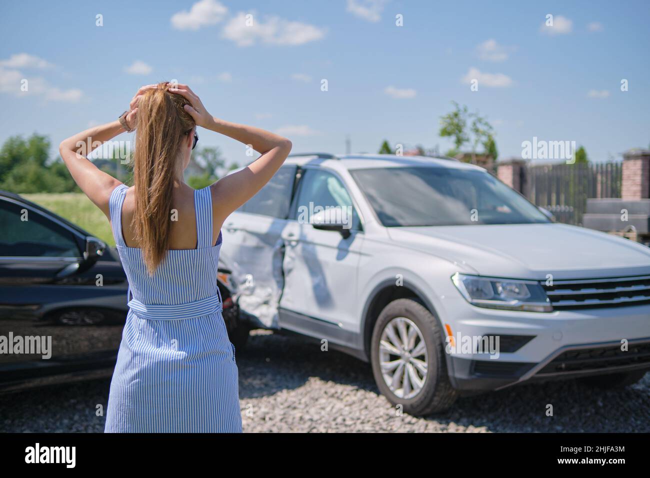 Sad female driver standing on street side shocked after car accident ...