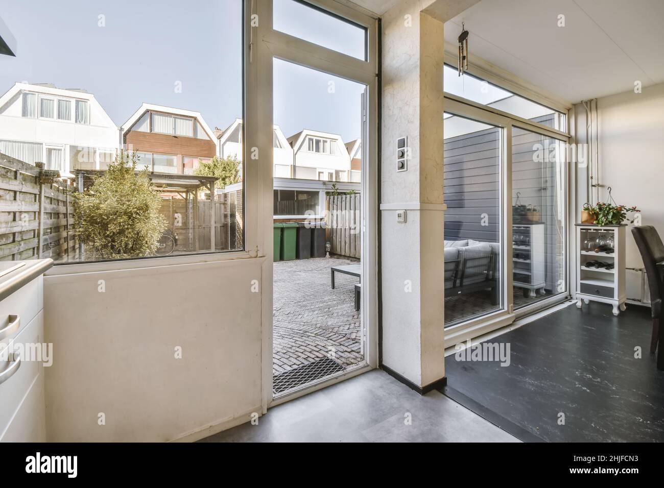 A huge window in a stylish room with a door overlooking the courtyard ...