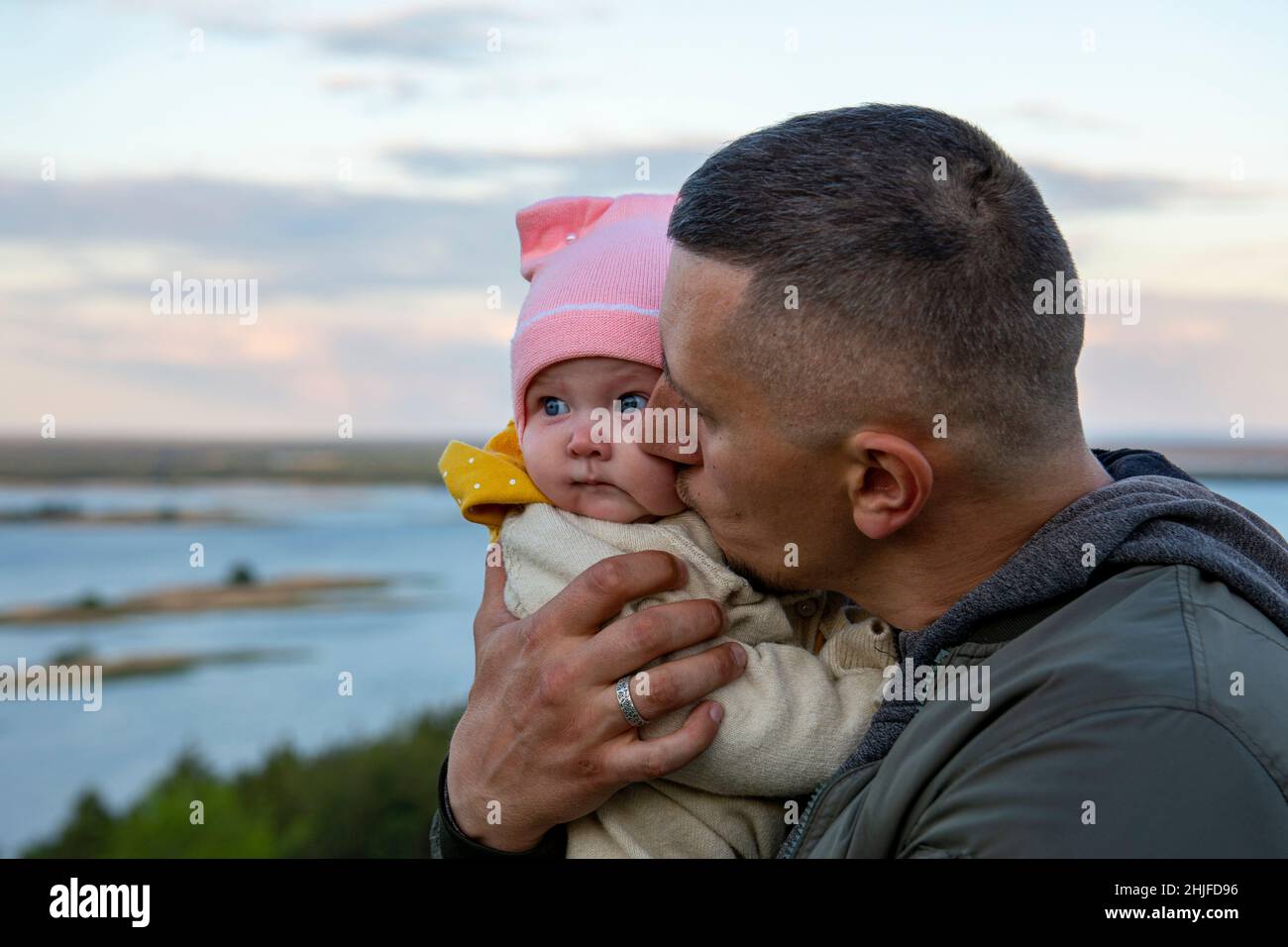 A young father with a tiny baby in his arms. The father loves his child ...