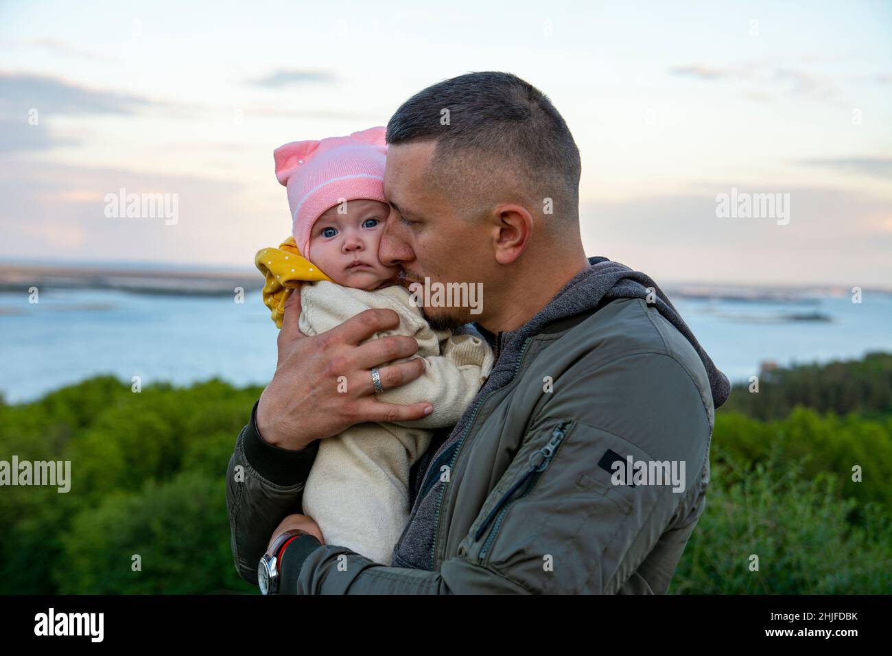 A young father with a tiny baby in his arms. The father loves his child ...